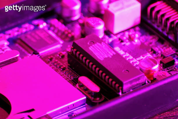Closeup view of complex modern pcb with processor in the pink neon ...