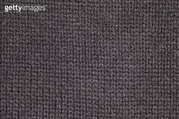 Fabric knitted with black spinning threads close-up knitting ...