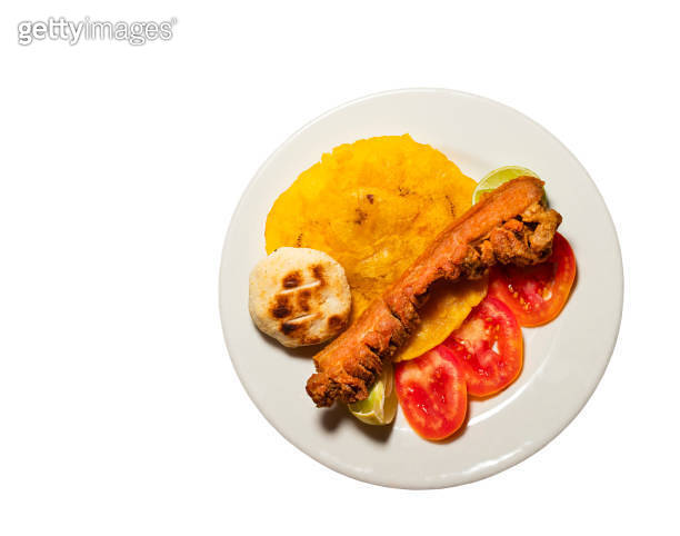 chicharron with patacones, arepa and sliced tomatoes - traditional ...