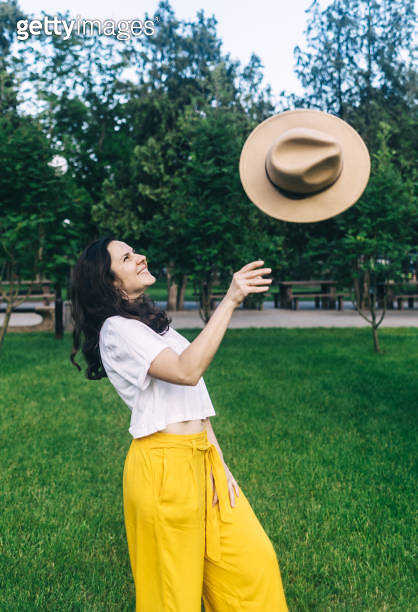 Throw hat. The girl dropped her brown hat and caught it. The concept of ...