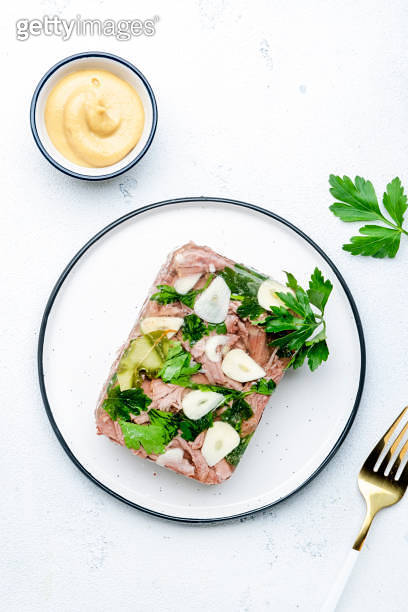 Aspic meat, cold boiled beef in spiced jelly broth on plate, dijon ...