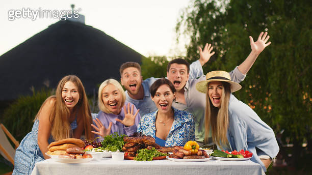 Outdoor dining table with delicious BBQ meats, fresh vegetables and ...