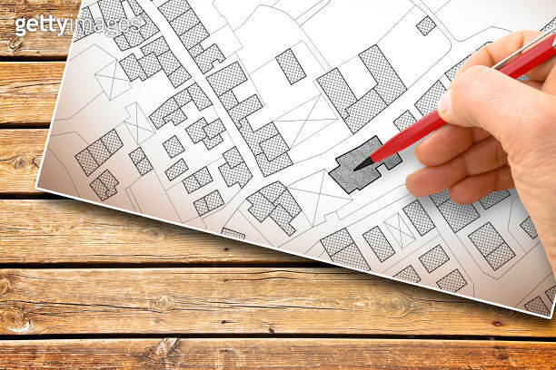 Hand drawing an imaginary cadastral map of territory with buildings and ...