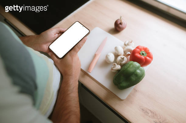 Using phone while cooking 이미지 (1592222872) - 게티이미지뱅크