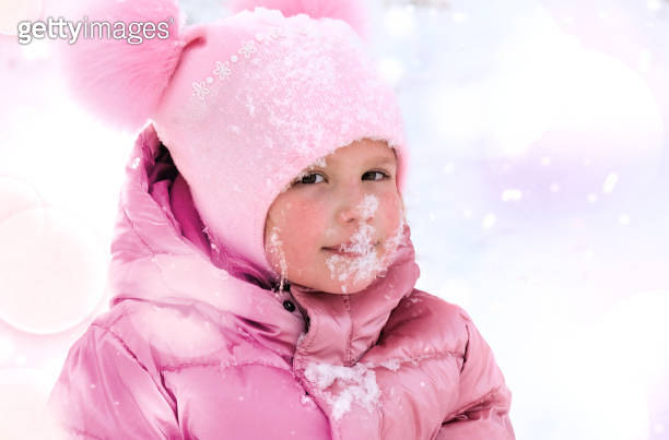 Cute baby girl with snow on her face, vacations, funny winter game ...