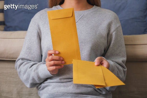 Closeup image of a woman holding and giving brown envelopes 이미지 ...