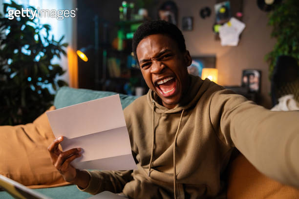 African American man receiving news screaming in celebration while ...