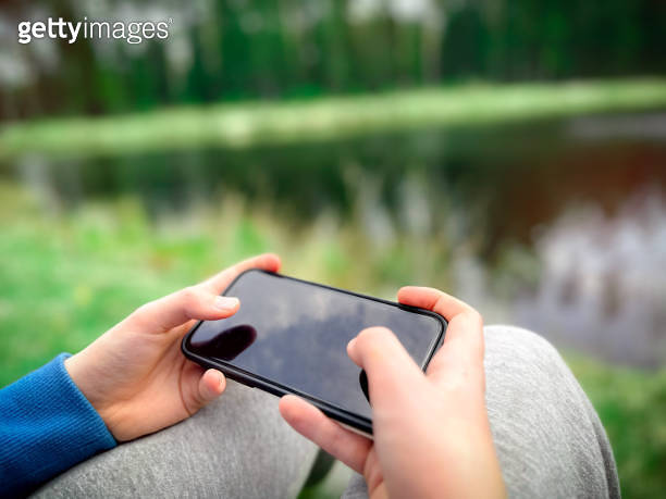 Using smartphone while relaxing in nature 이미지 (1481213150) - 게티이미지뱅크