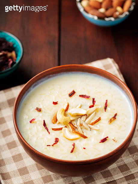 Rice pudding served in clay bowl. Indian rice kheer with nuts on a ...