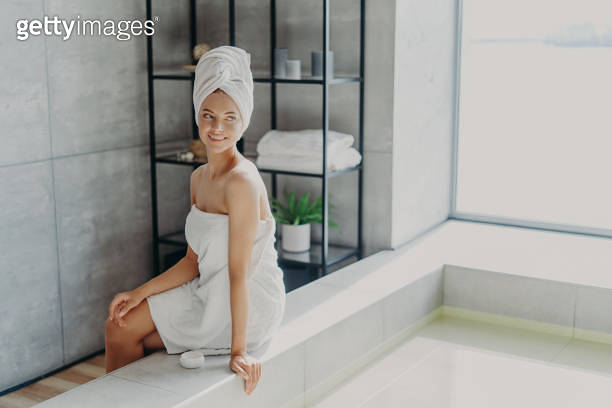 Beauty model with healthy perfect skin applies cream for body care ...