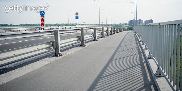 roadway of the bridge with metal railings high-rise buildings on the ...