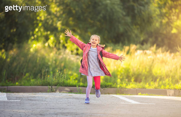 Happy little girl running after school 이미지 (1649440264) - 게티이미지뱅크