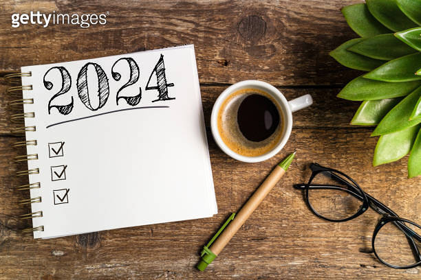New year goals 2024 on desk. 2024 goals list with notebook, coffee cup ...