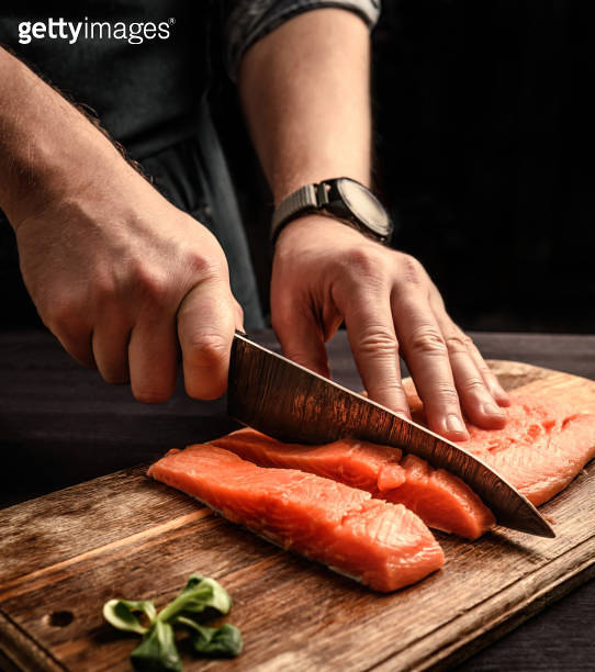 chief cutting a salmon fillet into pieces for cooking 이미지 (1494365878 ...