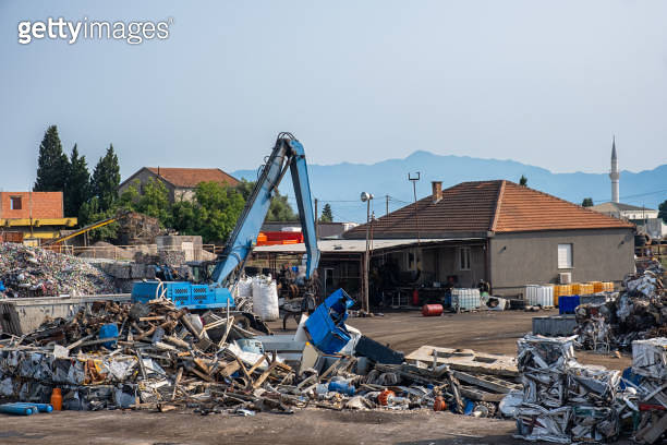 Grab crane works in waste recycling and sorting center. Scrap metal ...