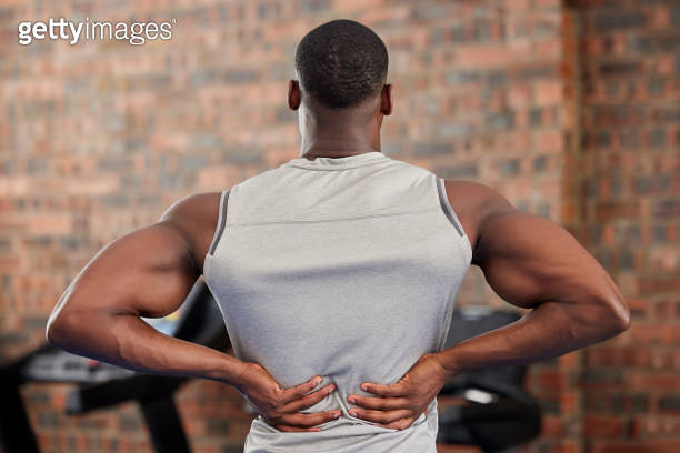 Back pain, fitness and exercise with a sports man suffering from an ...