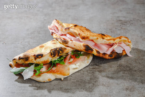 Folded flatbread sandwiches, various ingredients ham, prosciutto ...