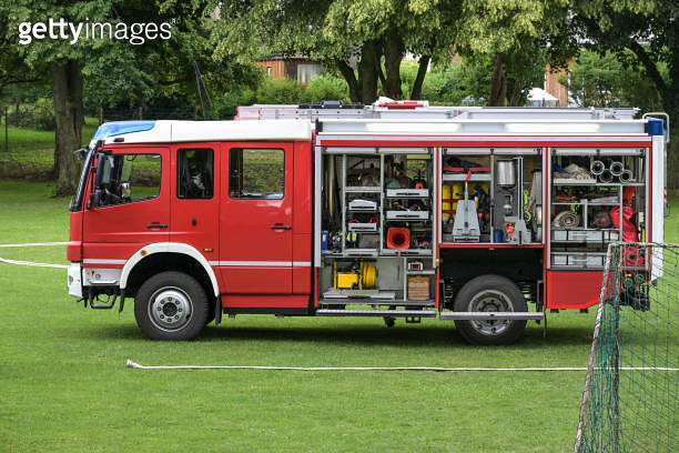 German fire engine, red truck with open roller shutter doors and the ...