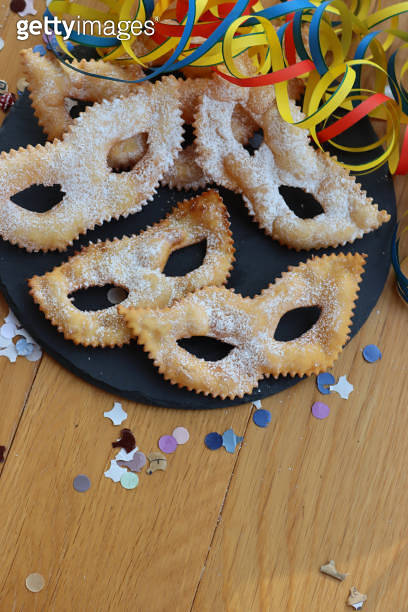 Traditional sweet crisp pastry deep-fried in shape of Carnival mask on ...