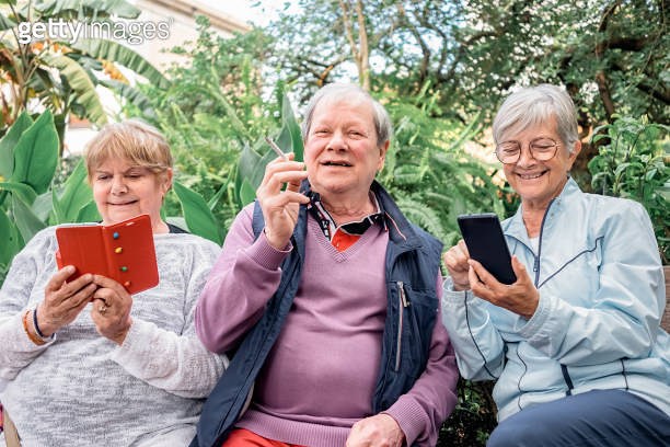 Group of relaxed senior retirees sitting in public park together ...