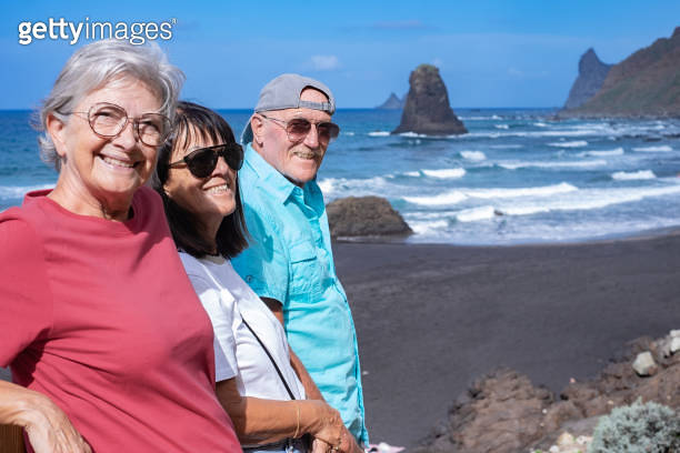 Cheerful group of senior friends enjoying vacation at sea exploring one ...