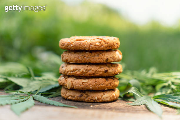Marijuana leaf and sweets on wooden brown table. Cannabis flowers and ...