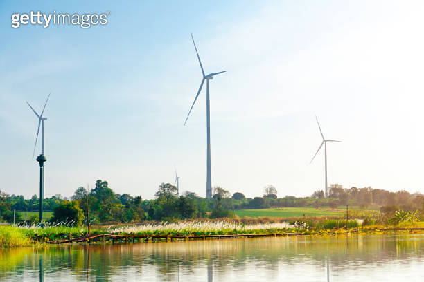 An electric wind turbine is located on top of a mountain. Reflection on ...
