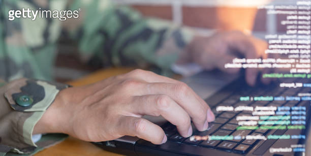 close up soldier man as programmer hand typing command on keyboard ...
