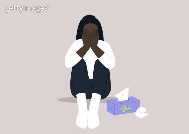 A young, lonely character sits on the floor covering their face, beside ...