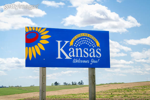 Kansas welcomes you - welcome roadside sign with a popular Latin phrase ...