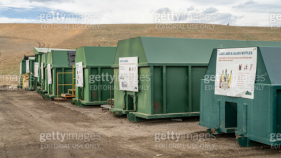 Recycling center - a row of green steel containers with instruction ...