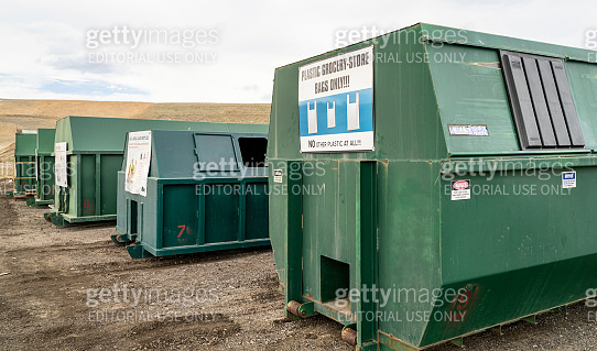 Recycling center - a row of green steel containers with instruction ...