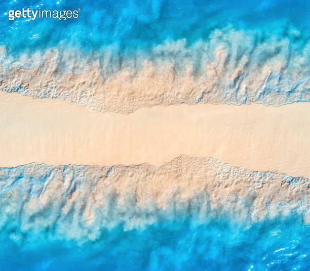 Aerial view of transparent blue sea with waves on the both sides and ...