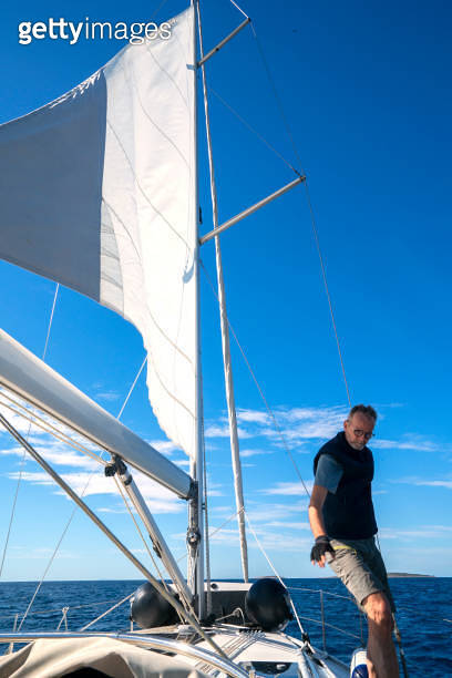 Man standing on the edge of sailing boat, sailing like having a sea ...
