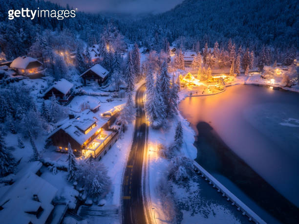Aerial view of fairy town in snow, road, forest, Jasna lake and houses ...