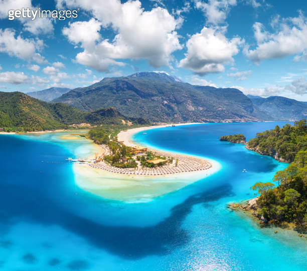 Aerial view of sea bay, empty sandy beach with umbrellas, trees ...