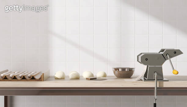 Beautiful, clean wooden table with fresh pasta dough, stainless steel ...