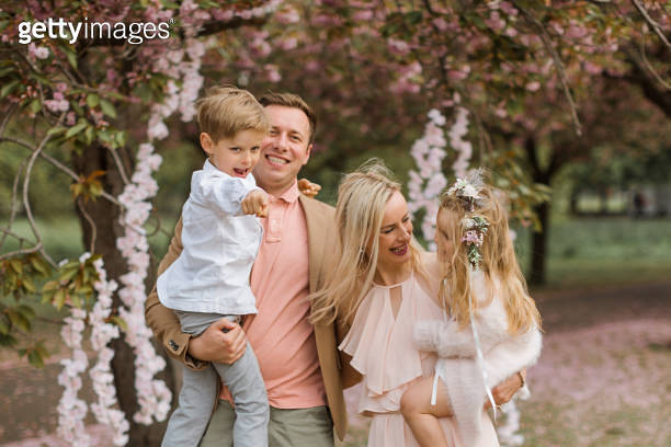 Spring. Happy couple in sakura park. Happy family in spring garden ...