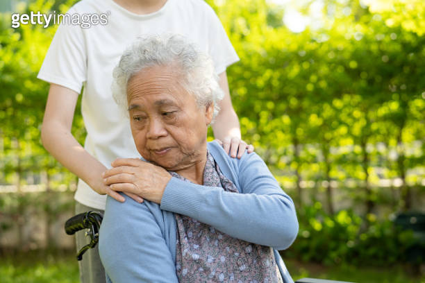 Caregiver help and care Asian senior or elderly old lady woman patient ...