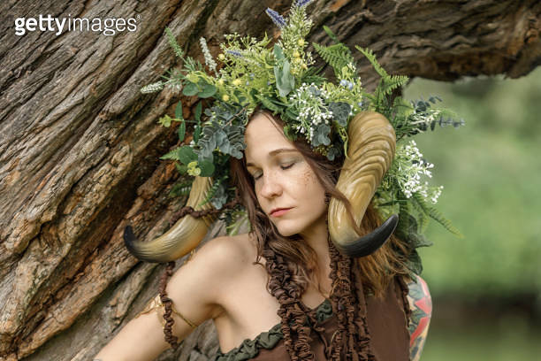 A pretty young faun in the woods. Mythological forest creature at the ...