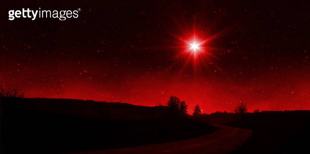 Bright red star shines over the road at night. Birth of Jesus concept ...