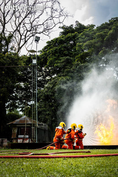 Firefighter Concept. Fireman using water and extinguisher to fighting ...