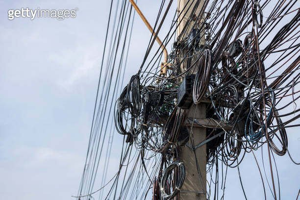 Intertwined electric wires. A tangled electrical wires showcasing the ...