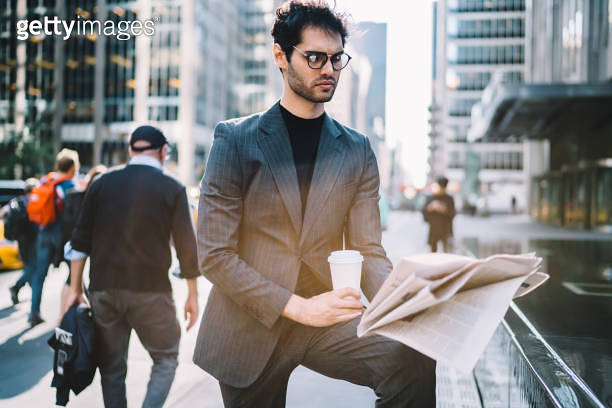 Serious male 30s interested on publicated article in morning newspaper ...