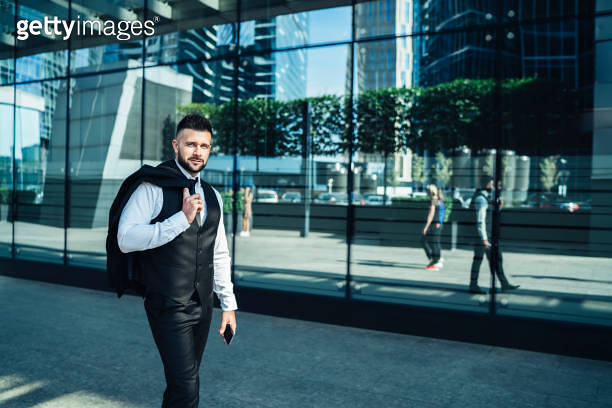 Adult dedicated executive man walking along street in downtown 이미지 ...