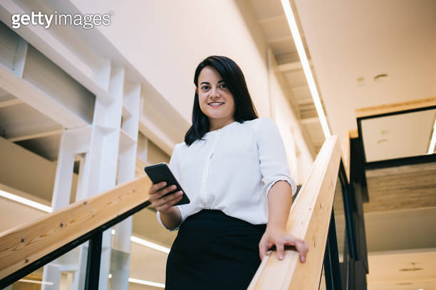 Portrait of attractive caucasian businesswoman in formal wear walking ...