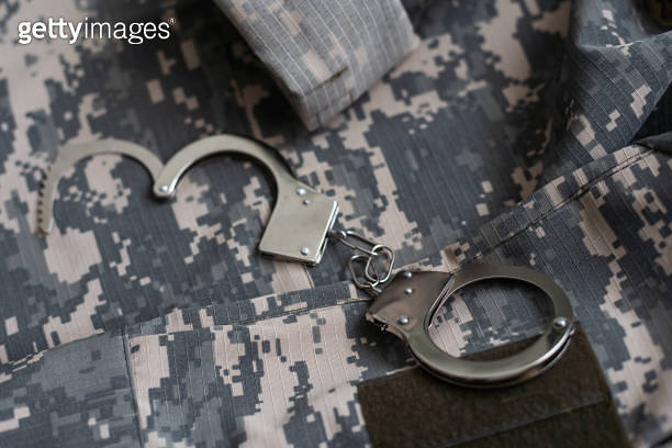 Handcuffs on a Camouflage background. Metal shackles isolated. Law ...