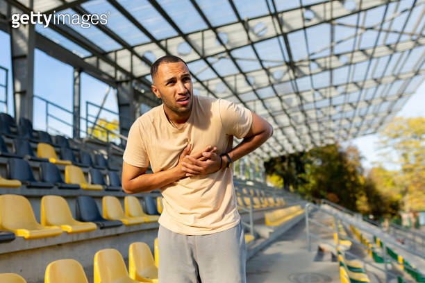 Sick athlete after jogging and vigorous exercise has severe chest pain ...