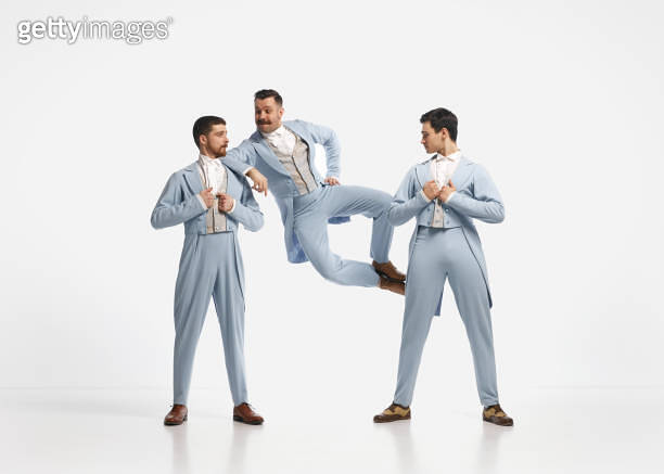 Portrait with three men wearing elegant clothes jumping and dancing ...