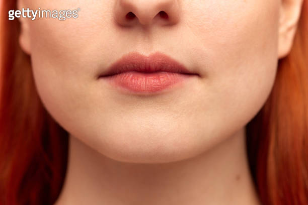 Cropped portrait with lower face of pretty young girl with red hair and ...